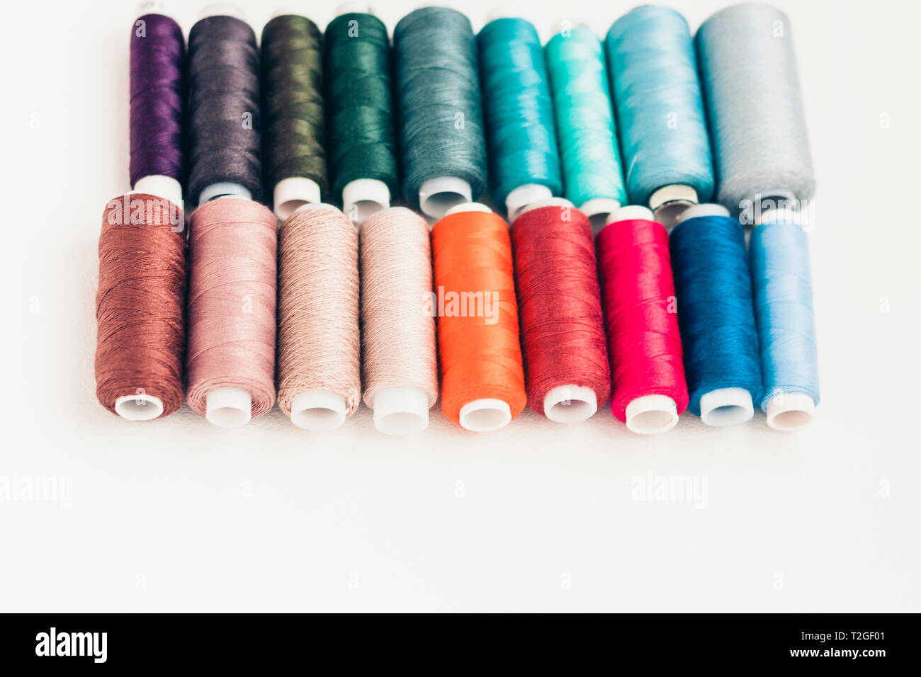 Colored sewing thread coils on white background with copy space for ...