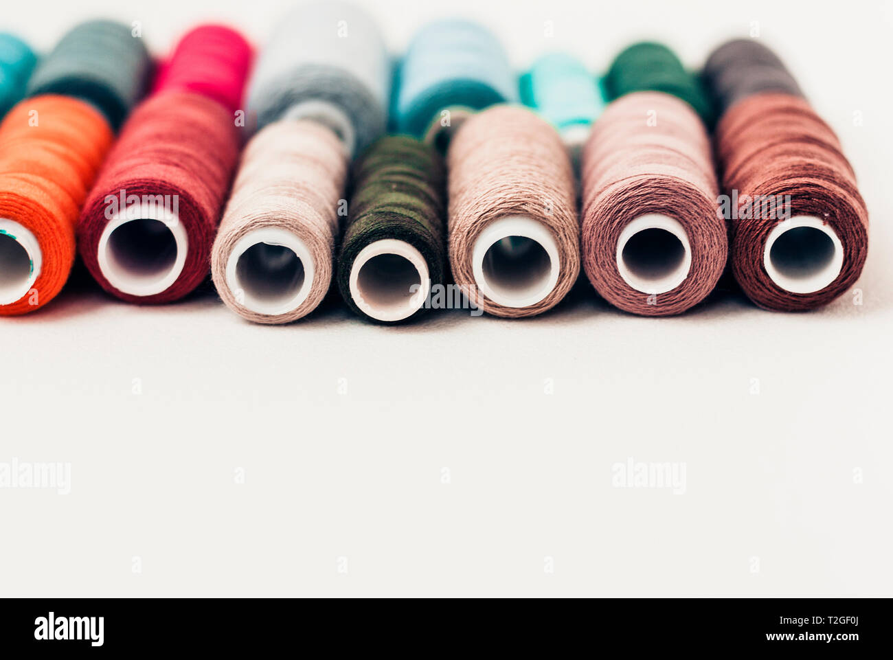 Colored sewing thread coils on white background with copy space for ...