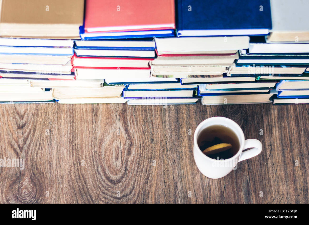 Stack of books education background, many books piles and cup of tea ...