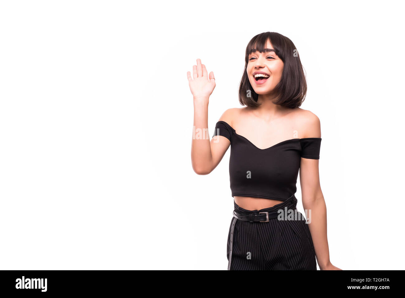 Full length portrait of a cheerful girl waving hand to camera isolated ...