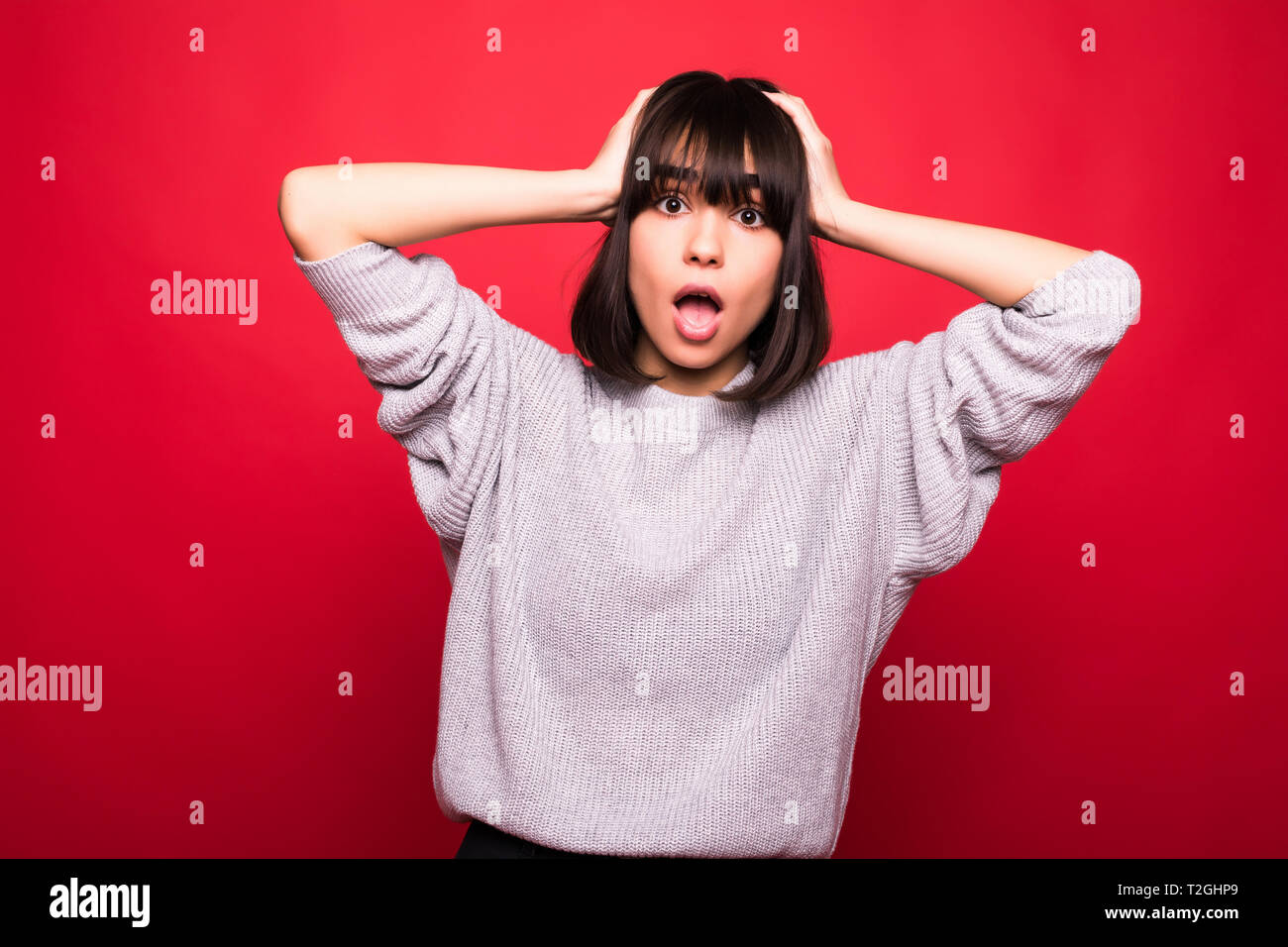 Portrait of a beautiful girl holding her hair being amazed agasint a ...