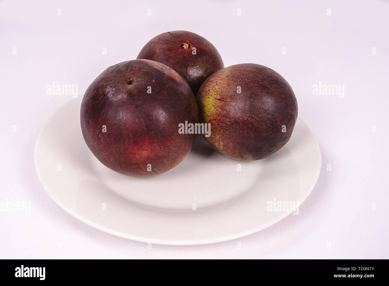 Three caimito fruits on a plate Stock Photo - Alamy