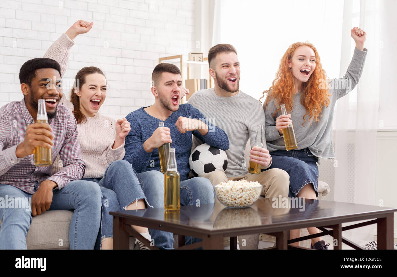 Happy football fans watching match on tv and celebrating victory at ...