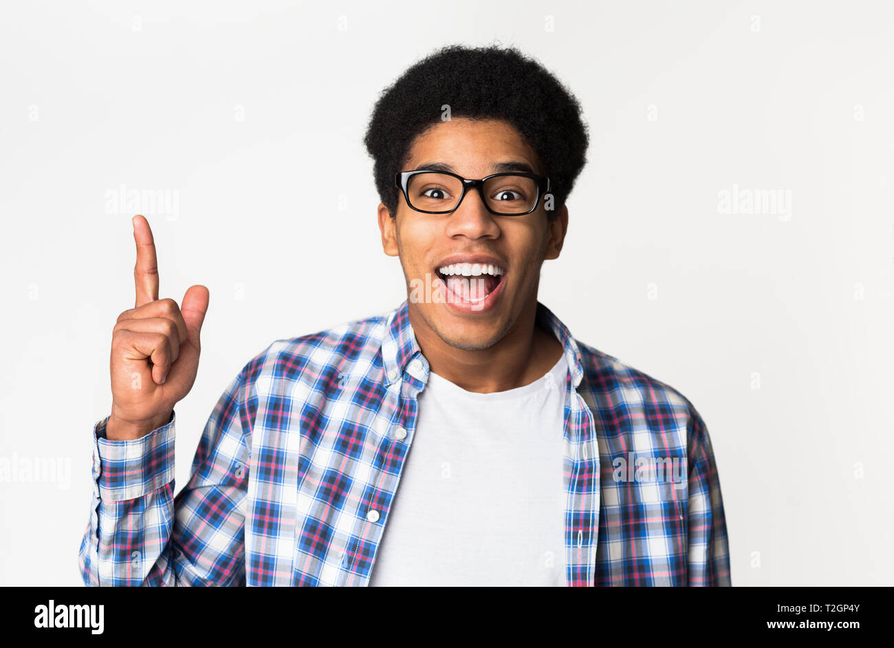 Guy having idea, pointing finger up and looking at camera over light ...