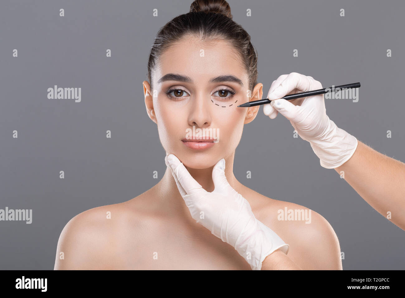Plastic surgery concept. Doctor drawing marks on female face before ...