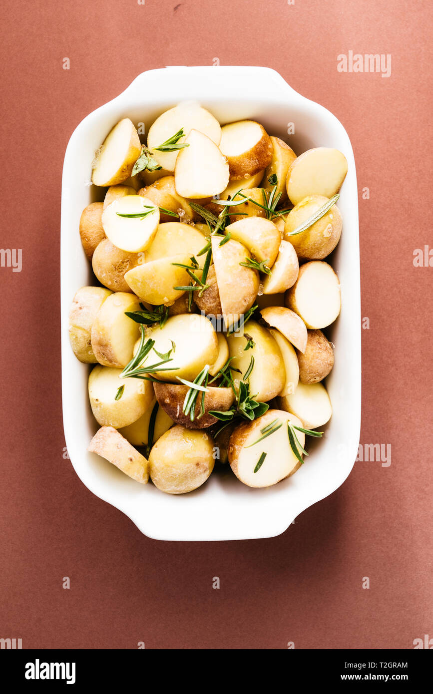 Baby jacket potatoes with herb and garlic oil dressing, on a white ...