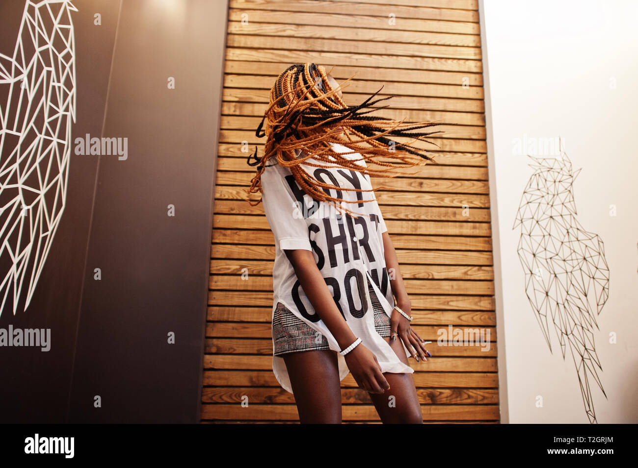 Beautiful african woman in stylish casual clothes posing against angel ...