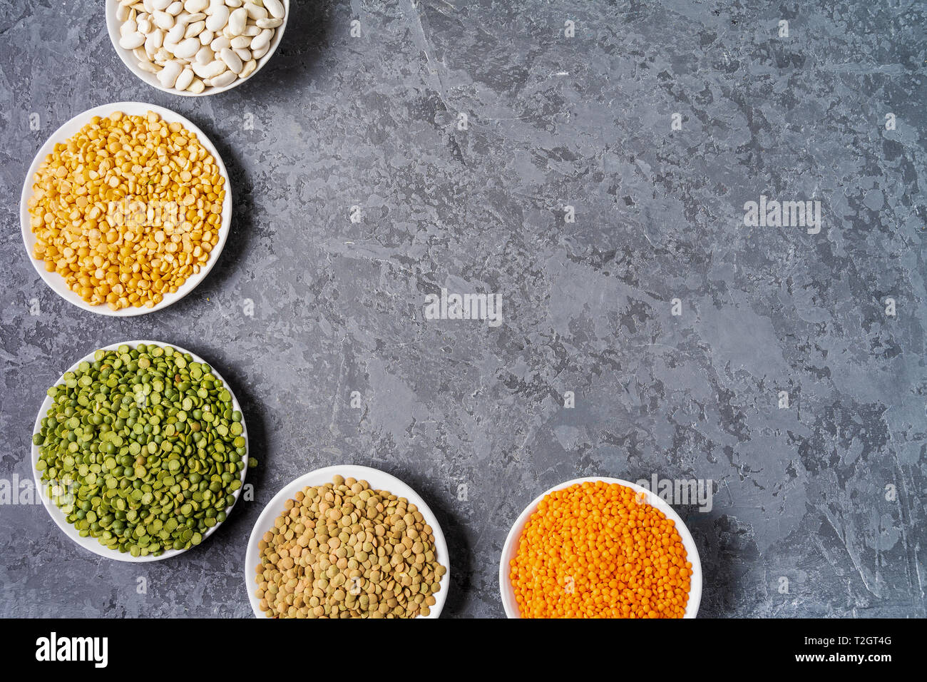 Top view of assortment of peas, lentils, beans and legumes over gray ...