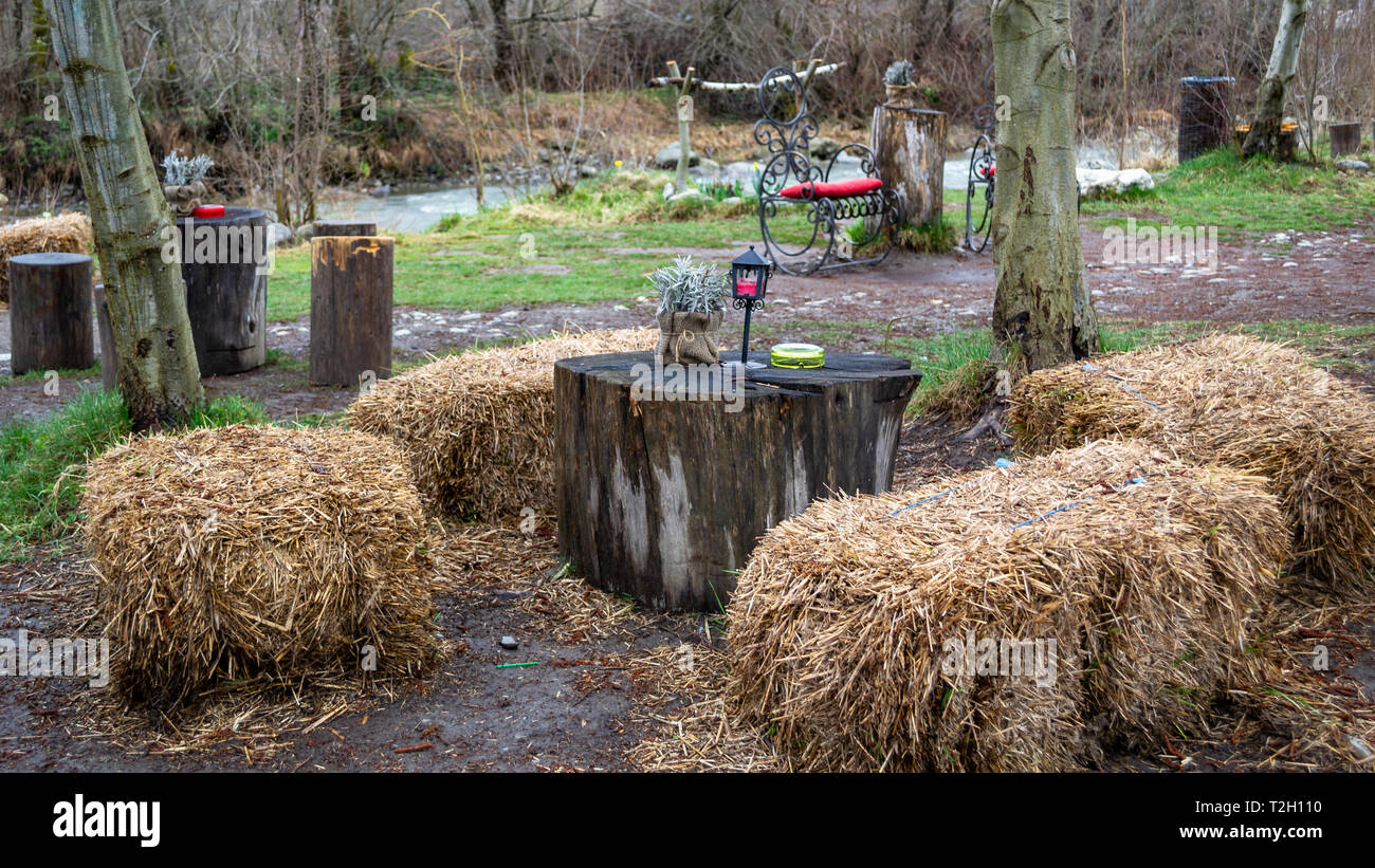 Haystacks used as chairs with a tree log as table, outdoor in rural ...