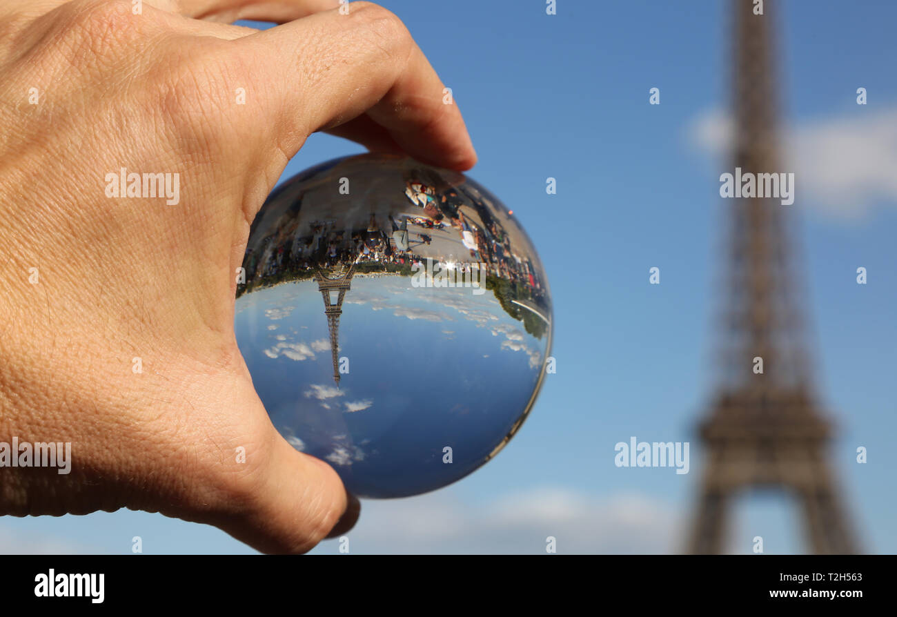 Big Crystal Sphere on the hand of a man and the Eiffel Tower in Paris ...