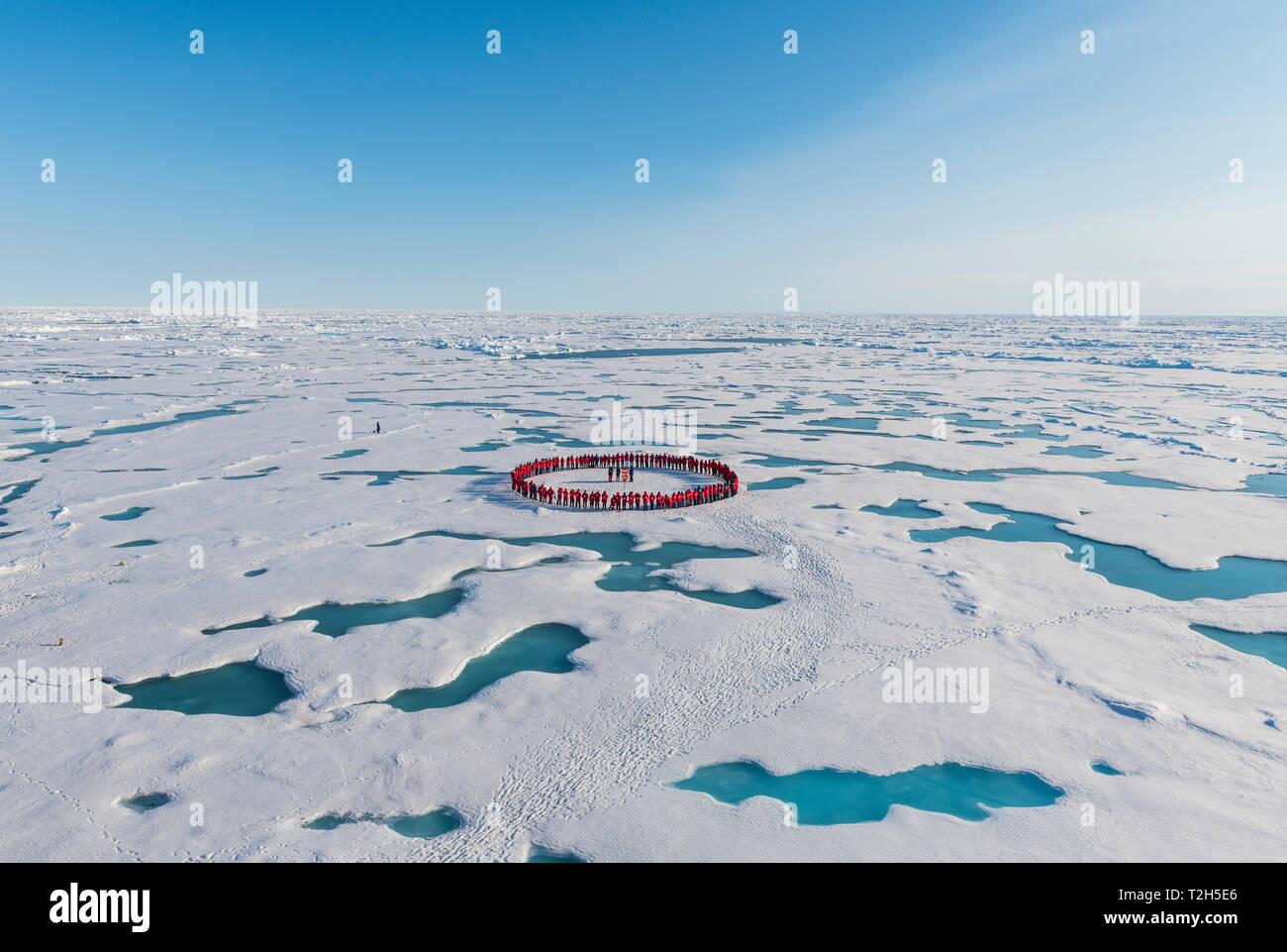 People wearing red forming circle around North Pole, Arctic Stock Photo ...