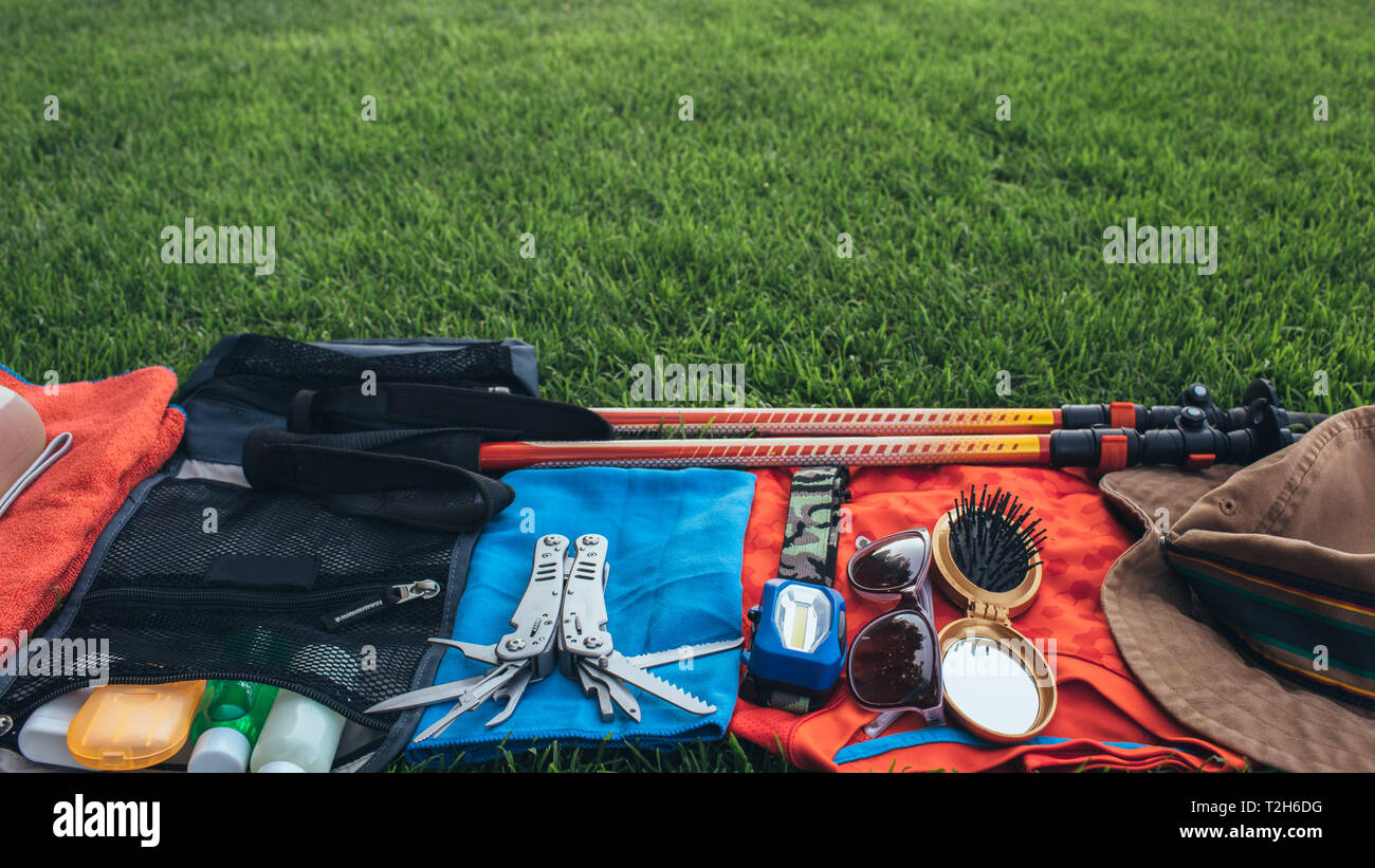 Set of equipment for hiking and travel on green grass with copy space ...