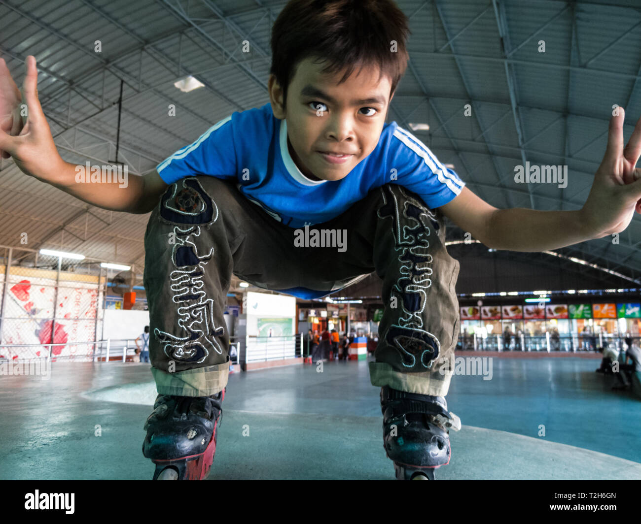 Young boy with hands in victory posture glides over to photographer on ...