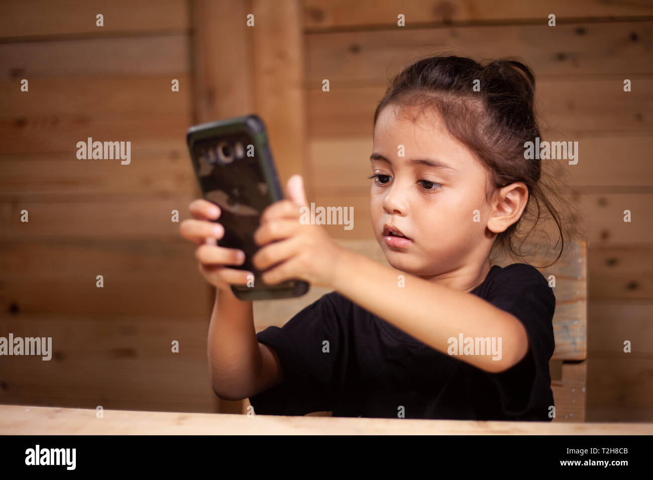 a boy wear black tee shirt watching his mobile in wooden room Stock ...