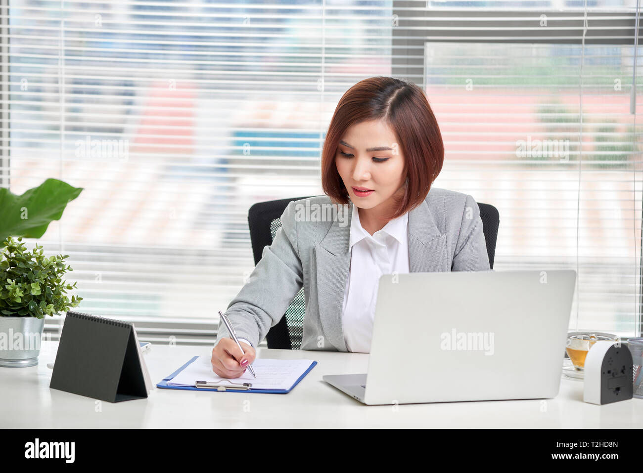 Woman writing in office planner hi-res stock photography and images - Alamy