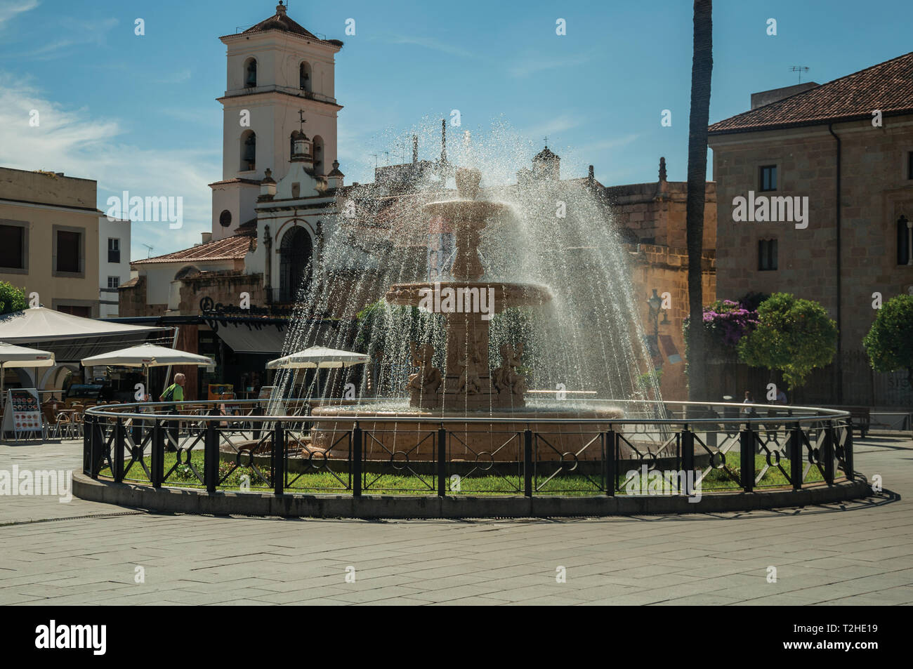 Graceful fountain with water squirt on a square in front of church at ...