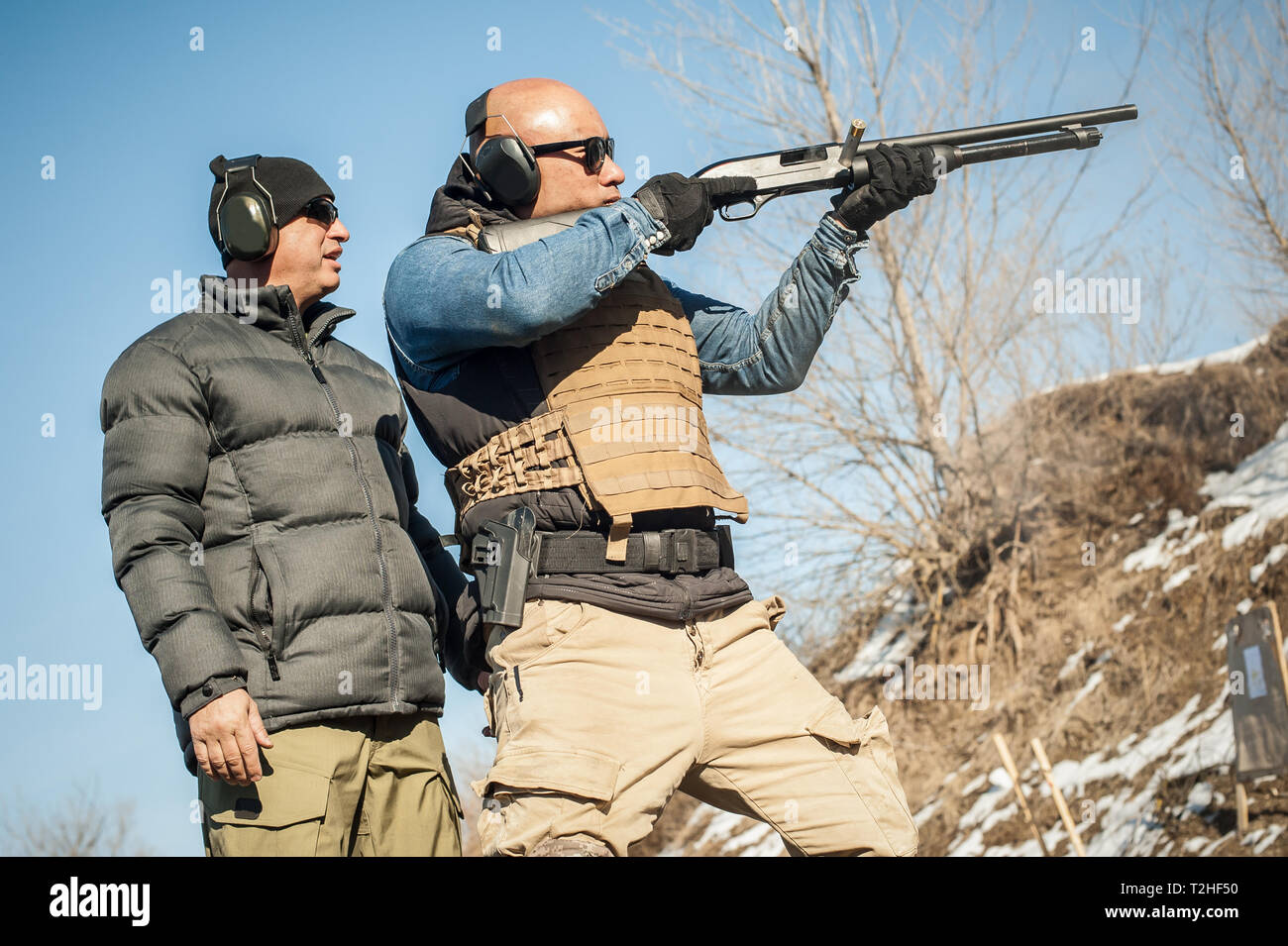 Instructor on shooting range teaches his student how to shoot with ...