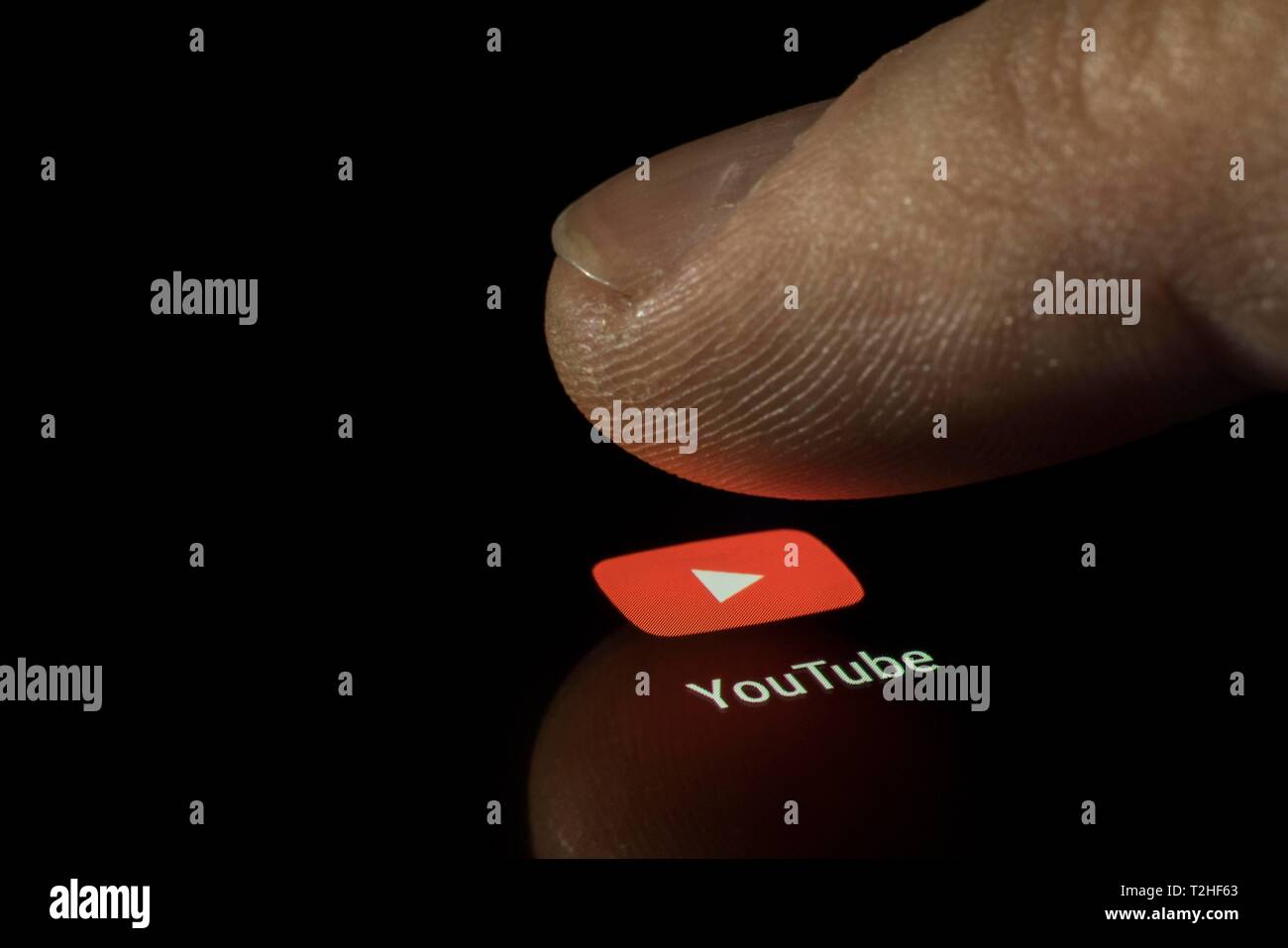YouTube app icon on a display, with finger, mobile phone, smartphone ...