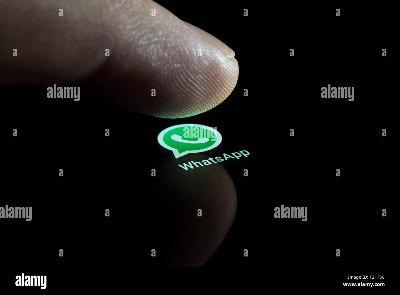 Whatsapp app icon on a display with finger hi-res stock photography and ...