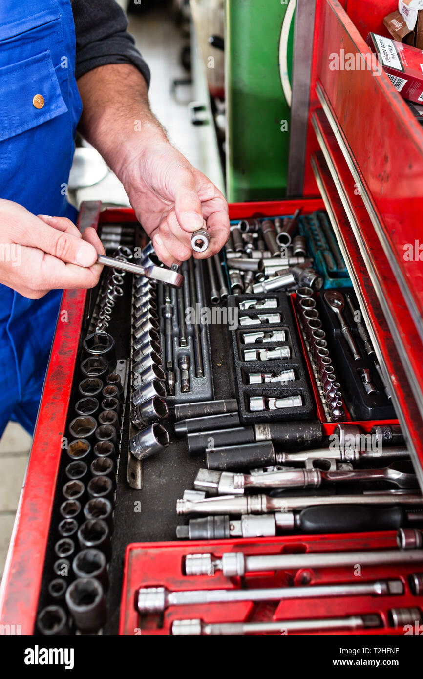 Mechanic man holding tool for repair and diagnostics of cars in the ...