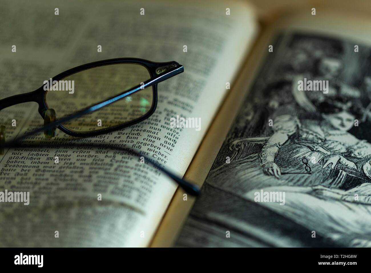 Opened old book with illustration and glasses, old German script ...