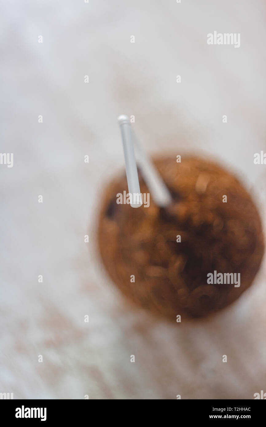 whole coconut with a cocktail straw on a white wooden background Stock ...