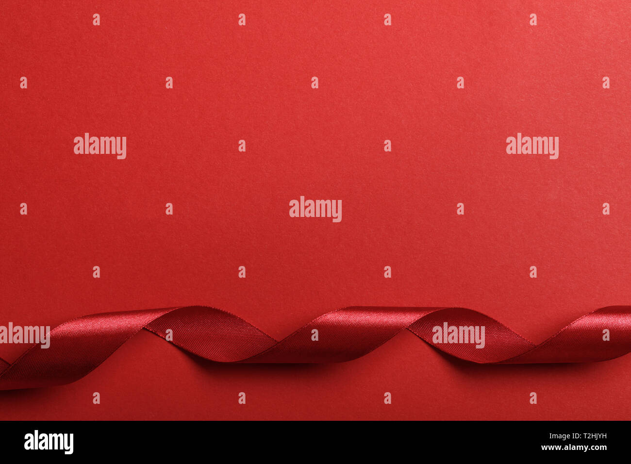 top view of curved silk red ribbon on red background Stock Photo - Alamy