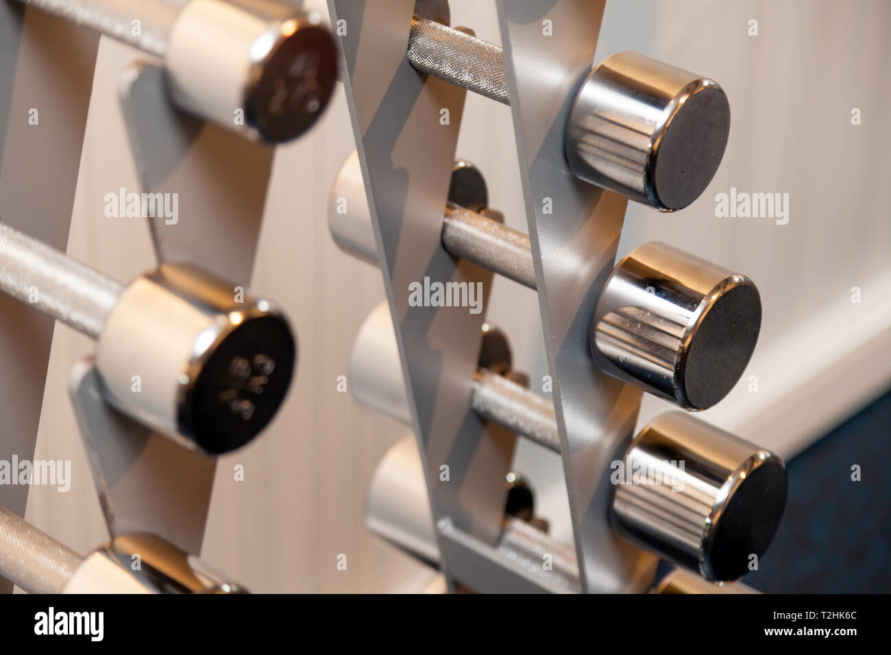 Closeup oshiny metal dumbbells, barbells, weights on the stand in ...