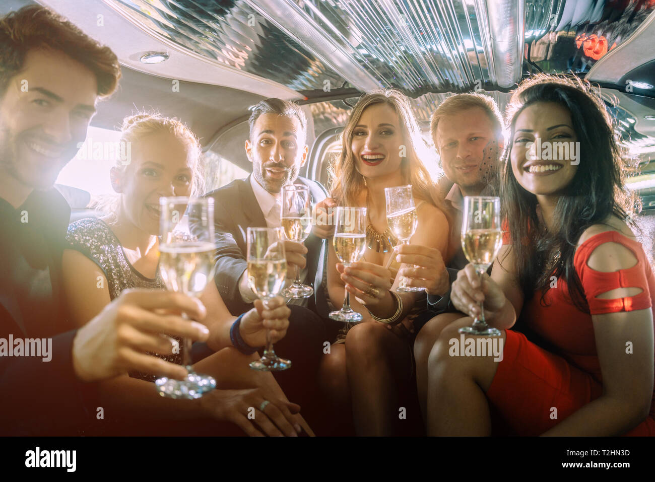 Group of party people in a limo drinking looking at the camera Stock ...