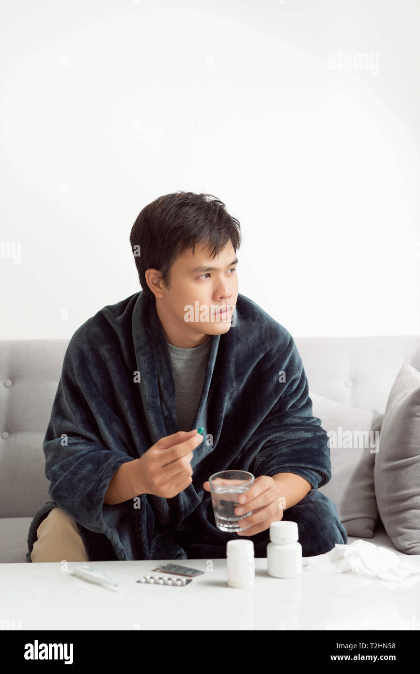 Handsome young man with pill and glass of water at home Stock Photo - Alamy