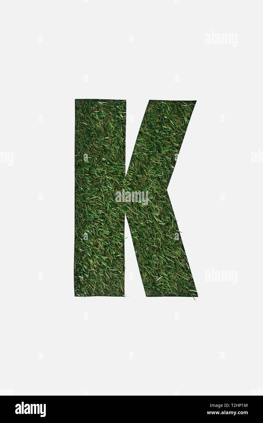 top view of cut out K letter on green grass background isolated on ...