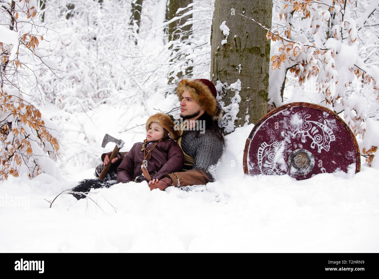 Father and son Vikings in a deep winter forest and the father teaches ...