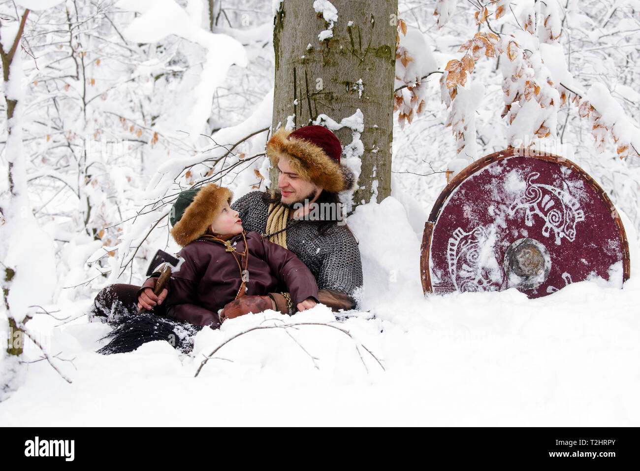 Father and son Vikings in a deep winter forest and the father teaches ...