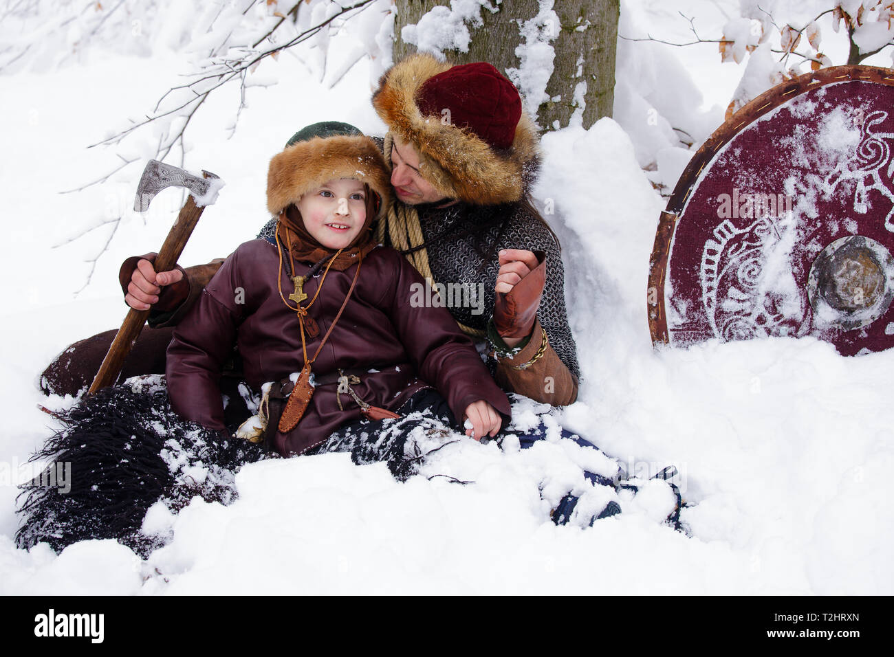 Father and son Vikings in a deep winter forest and the father teaches ...