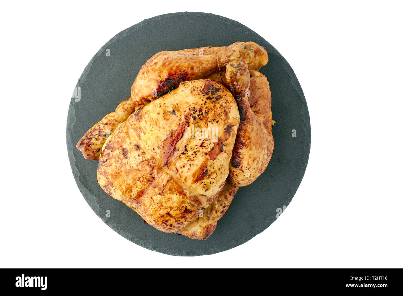 Roasted crispy chicken on round slate dish isolated over white ...