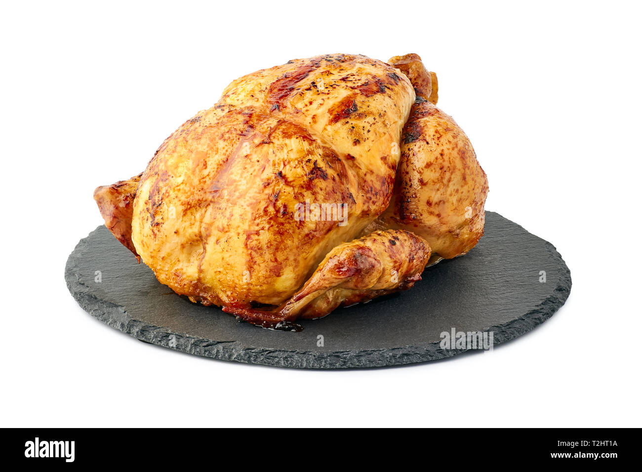 Roasted crispy chicken on round slate dish isolated over white ...
