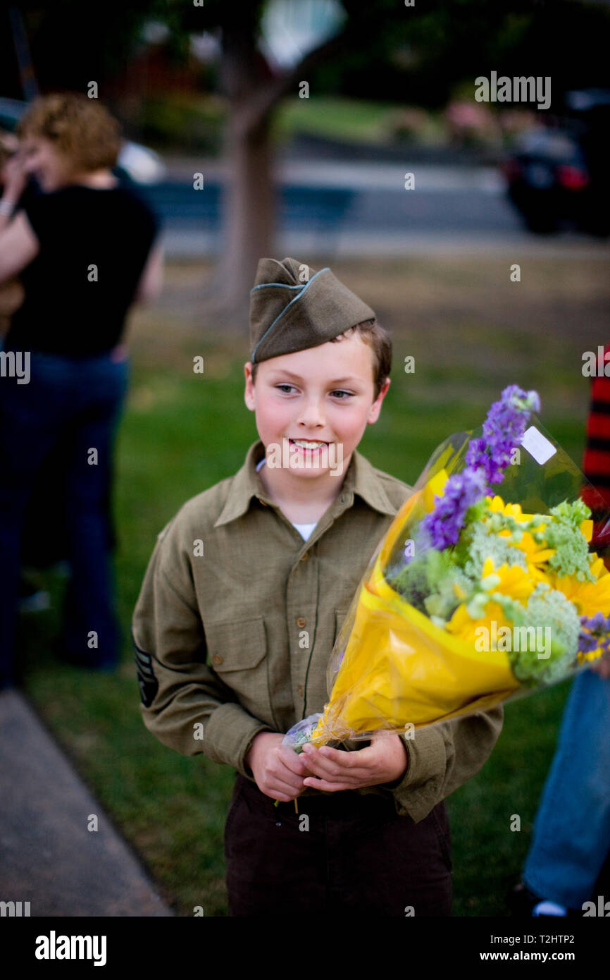 Boy in army uniform holding bouquet of flowers Stock Photo - Alamy