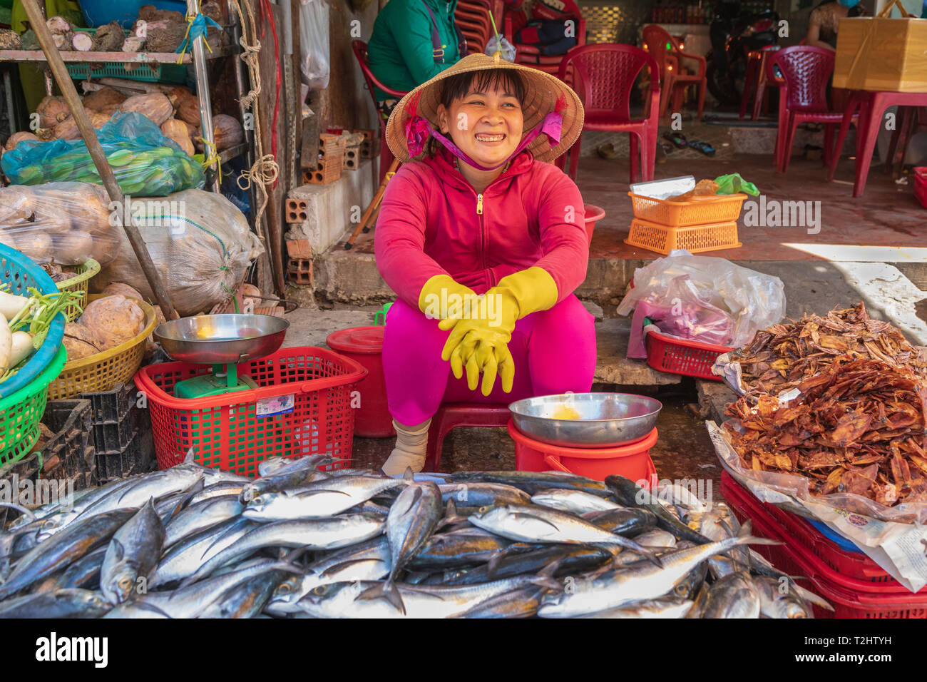 Vietnamese woman selling fish from a street stall at the outdoor street ...