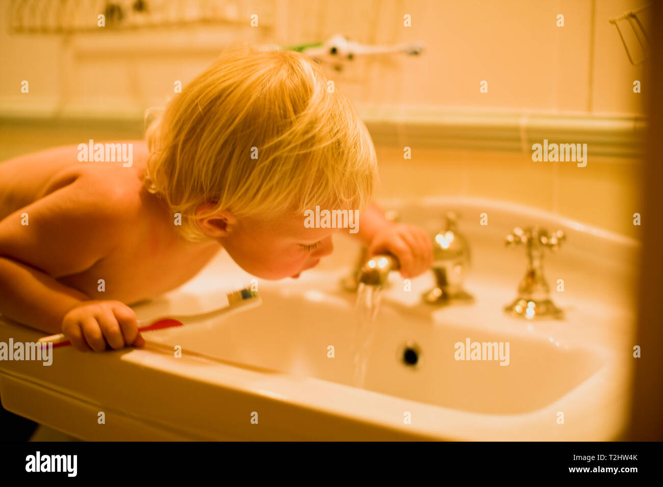 Shirtless toddler rinsing his mouth after brushing his teeth at the ...