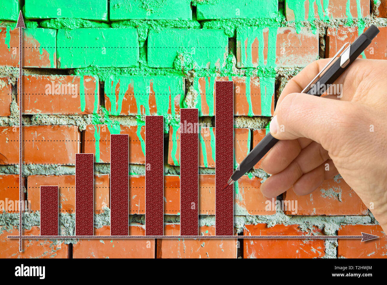 Hand draws a growing graph against a brick wall background - concept ...