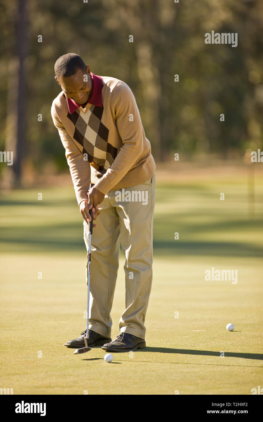 Man putting golf ball Stock Photo - Alamy