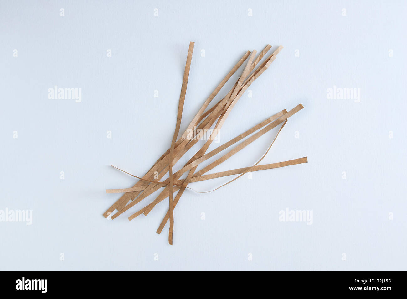 Brown paper cut into strips. View from above. White background Stock ...