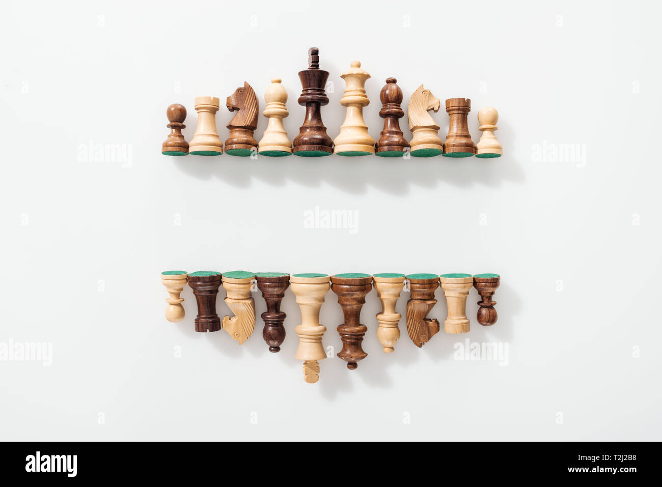 top view of rows made of wooden chess figures on white background with ...