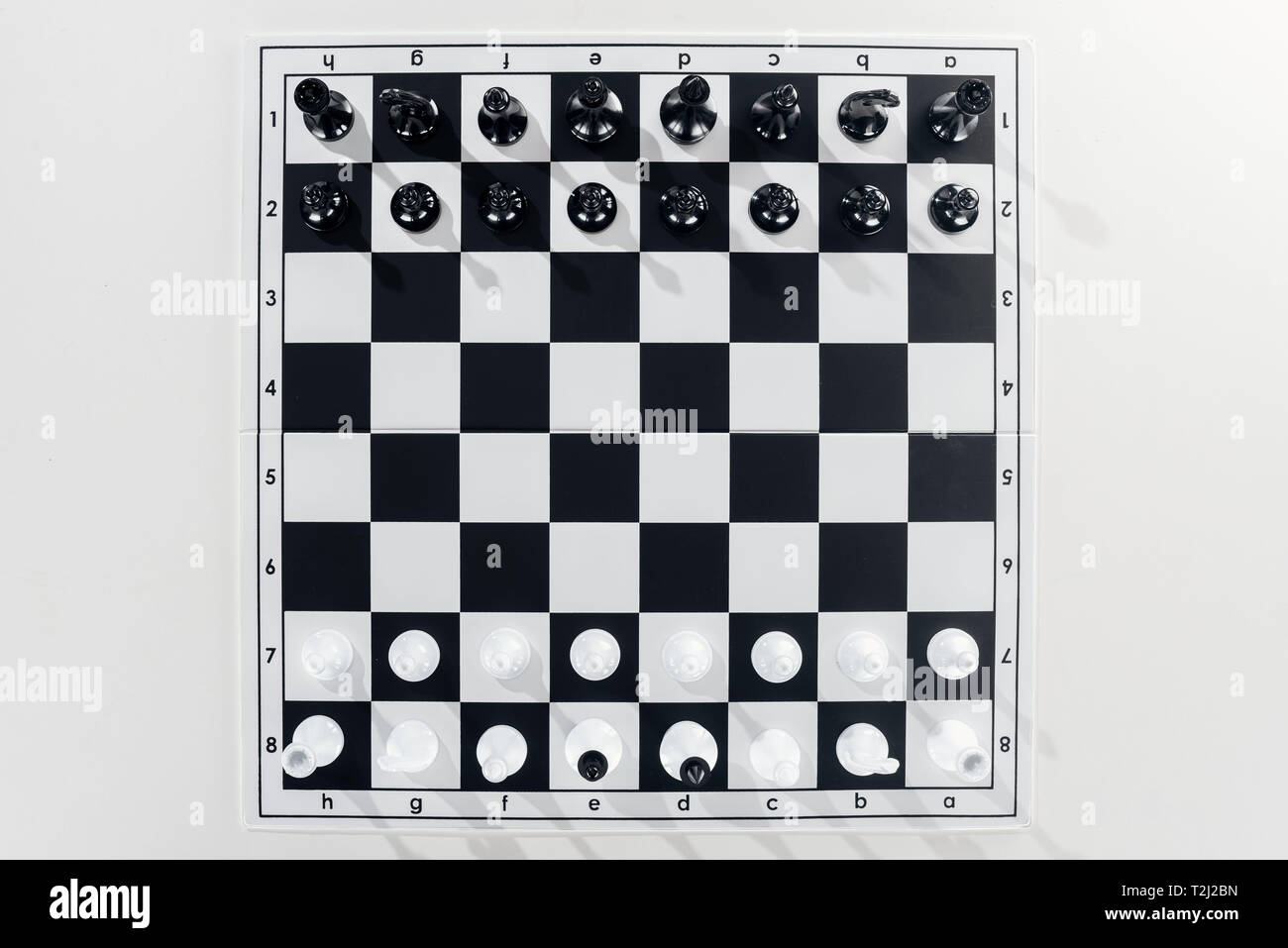 top view of black and white chessboard with chess figures on white ...