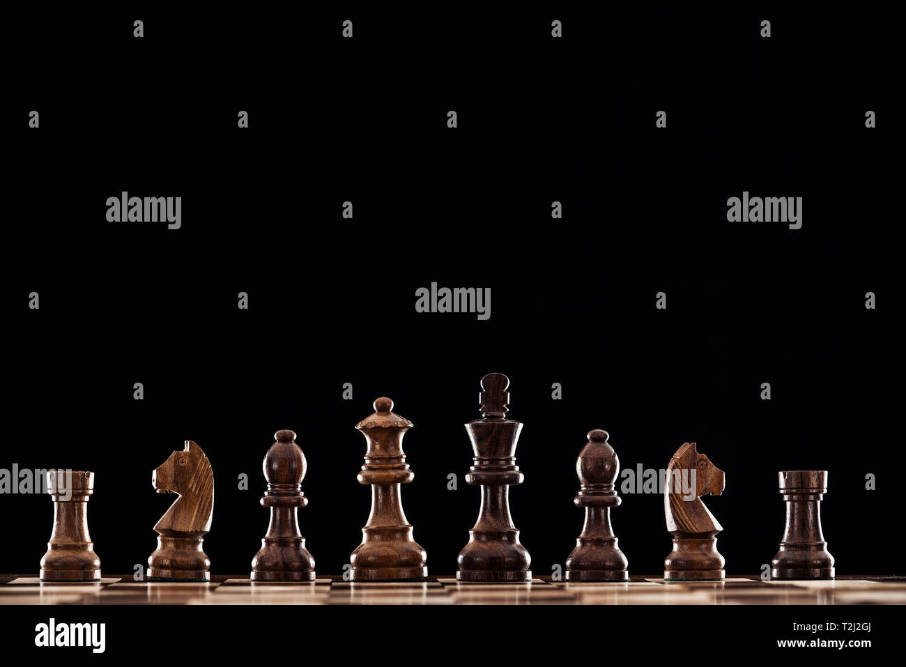 wooden chessboard with brown chess pieces isolated on black Stock Photo ...