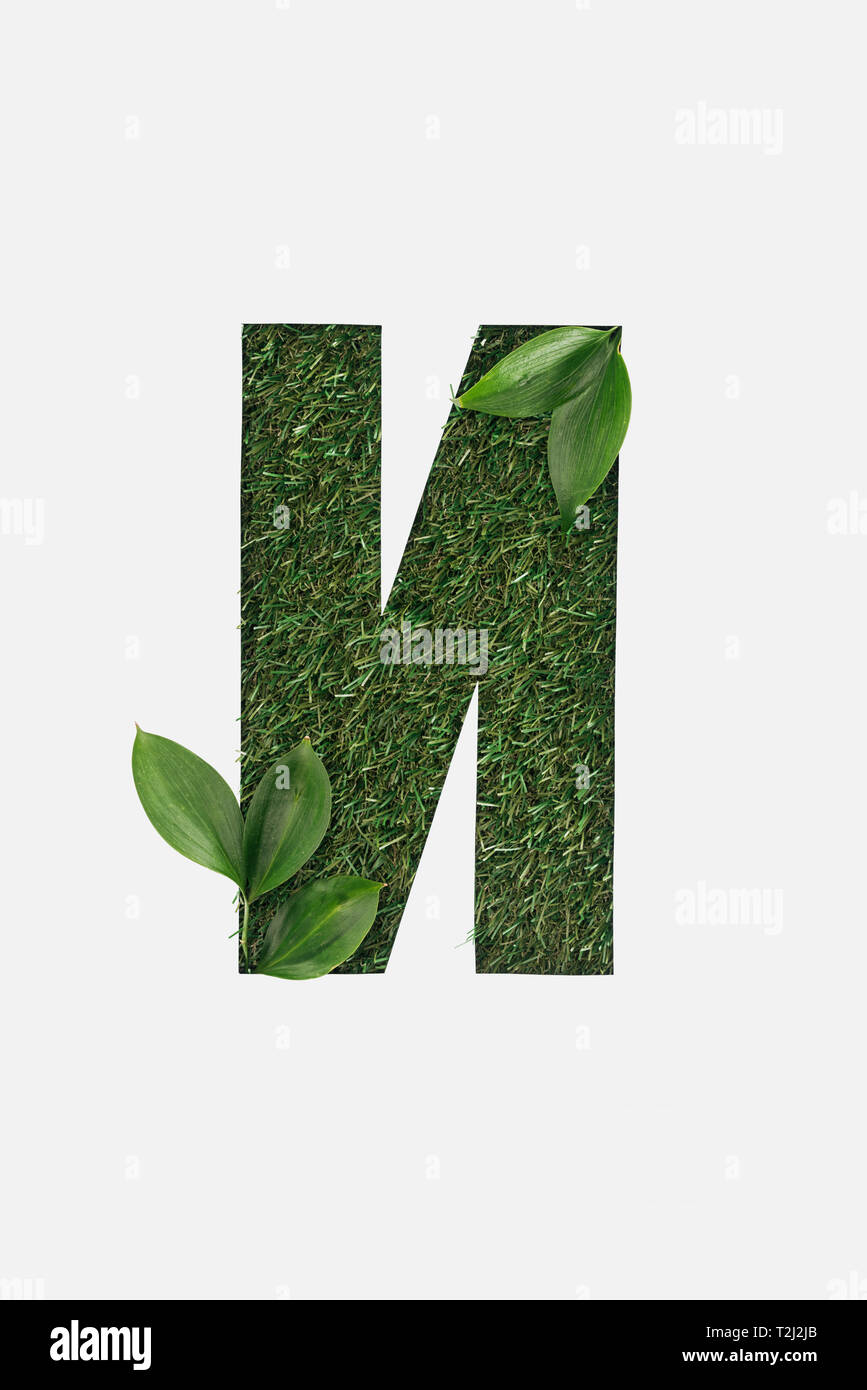 cut out cyrillic letter with fresh green grass on background and leaves ...