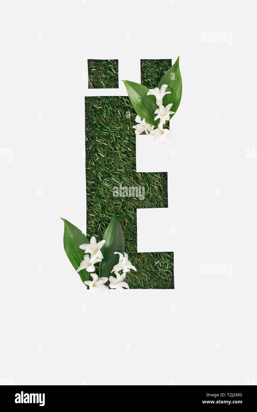 top view of cyrillic letter with natural grass on background and white ...