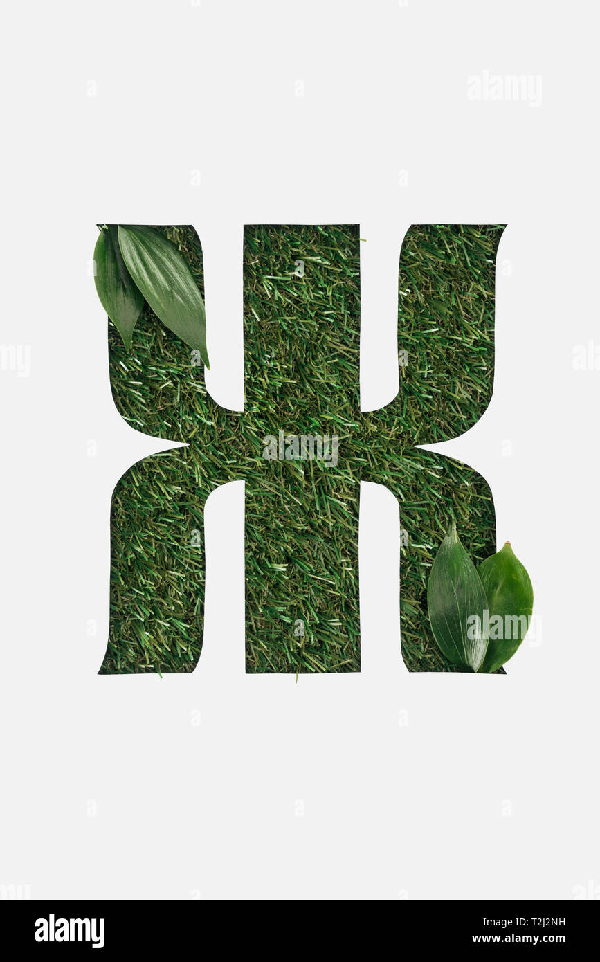 top view of cyrillic letter with green grass on background and fresh ...
