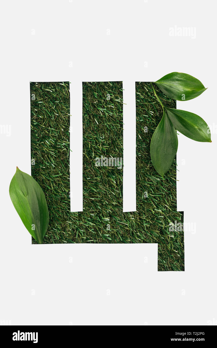 top view of cyrillic letter with green grass on background and green ...