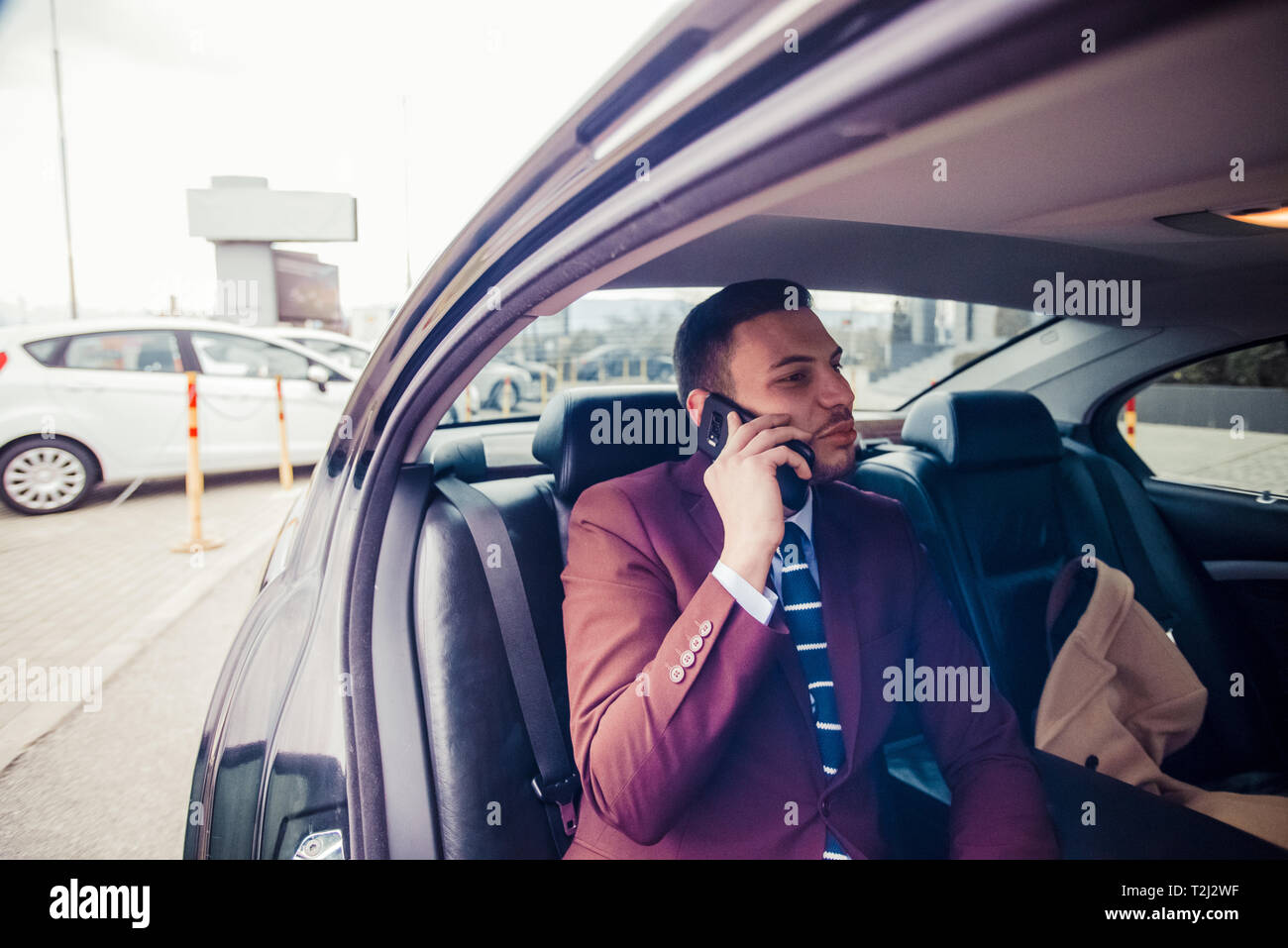 Man in suit is going to a meeting while driving in a limo Stock Photo ...